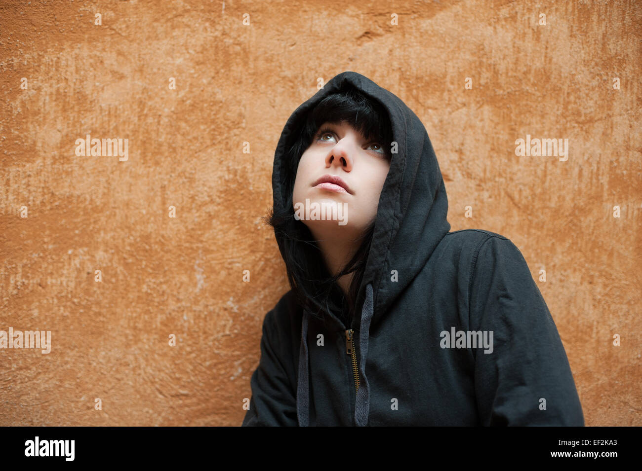 Dark young woman sad standing near urban wall portrait Stock Photo - Alamy