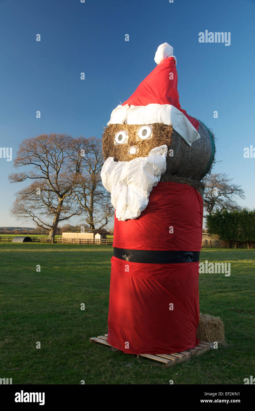Happy Xmas. A large comical figure of Santa Claus made out of hay bales ...