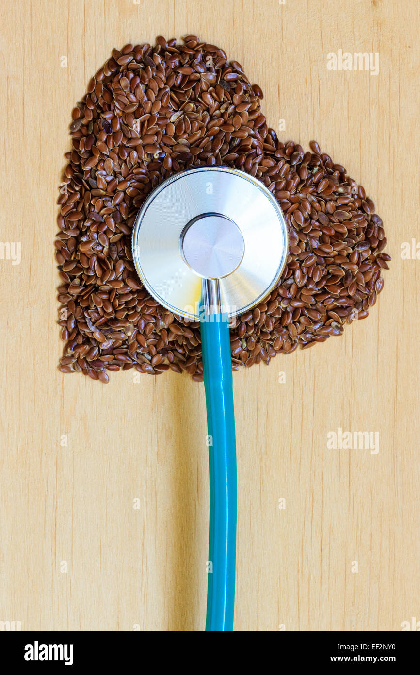 Diet healthcare and checkup concept. Raw flax seeds linseed heart shaped and stethoscope ...