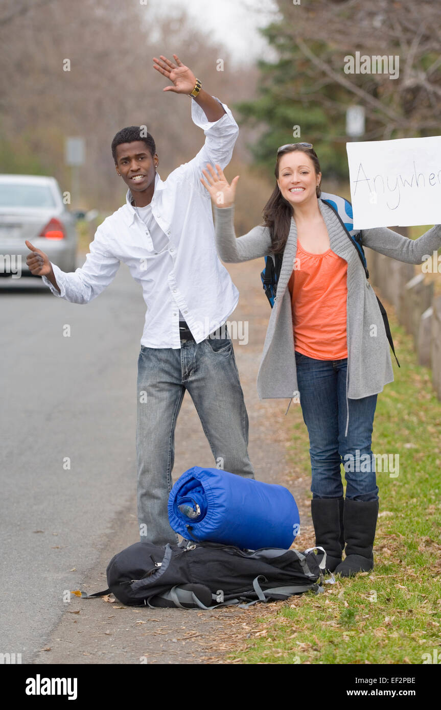 Two people hitchhiking Stock Photo - Alamy