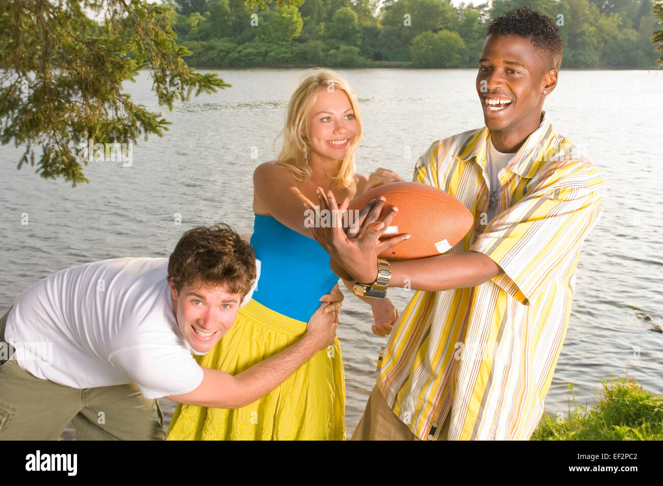 Three friends playing football Stock Photo - Alamy