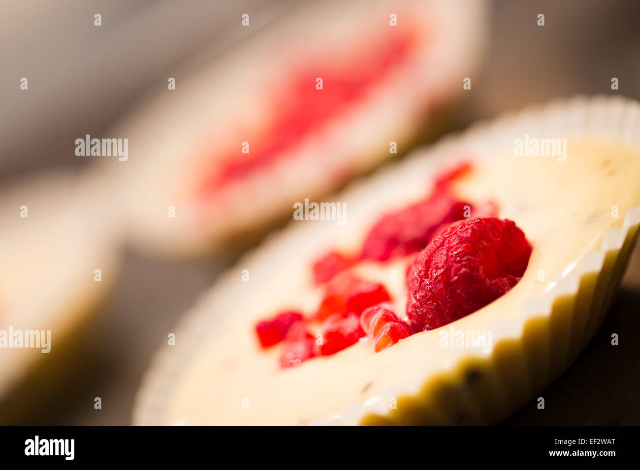 Baking uncooked raspberry and chocolate cupcake muffins Stock Photo - Alamy