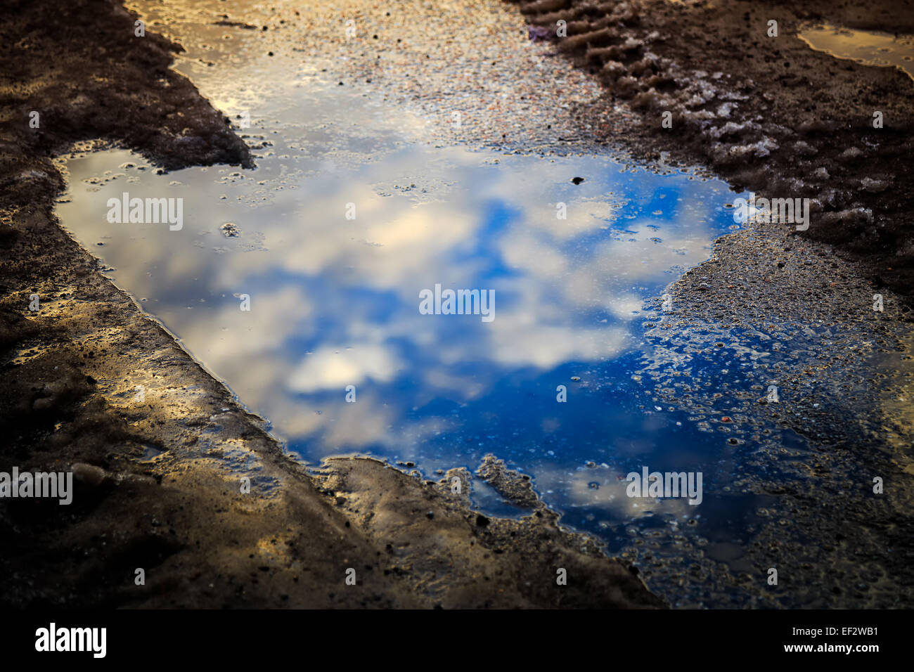 Reflection of blue sky and White Clouds in puddle on street Stock Photo ...