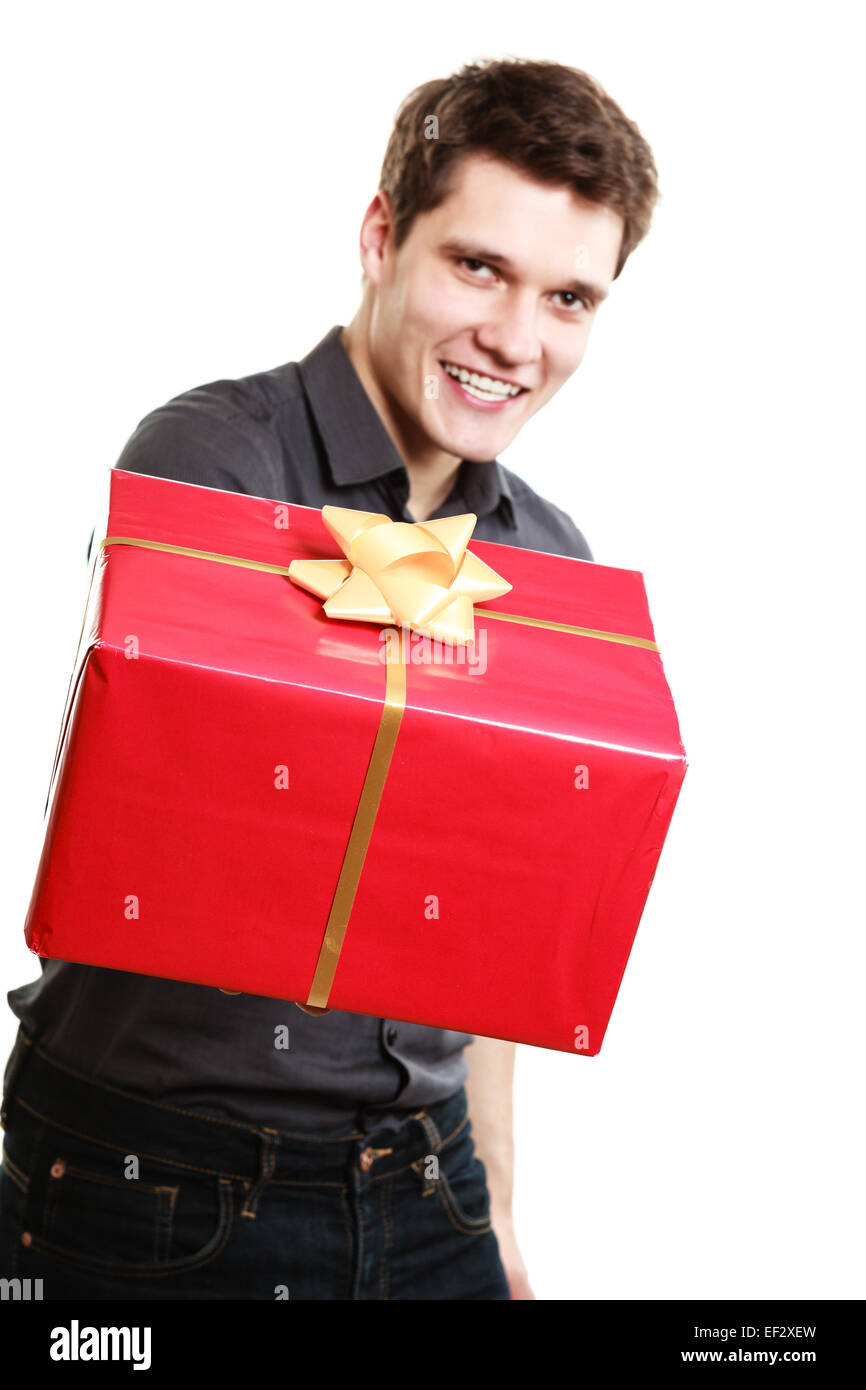 Holiday and special occasion. Young handsome man giving red present ...