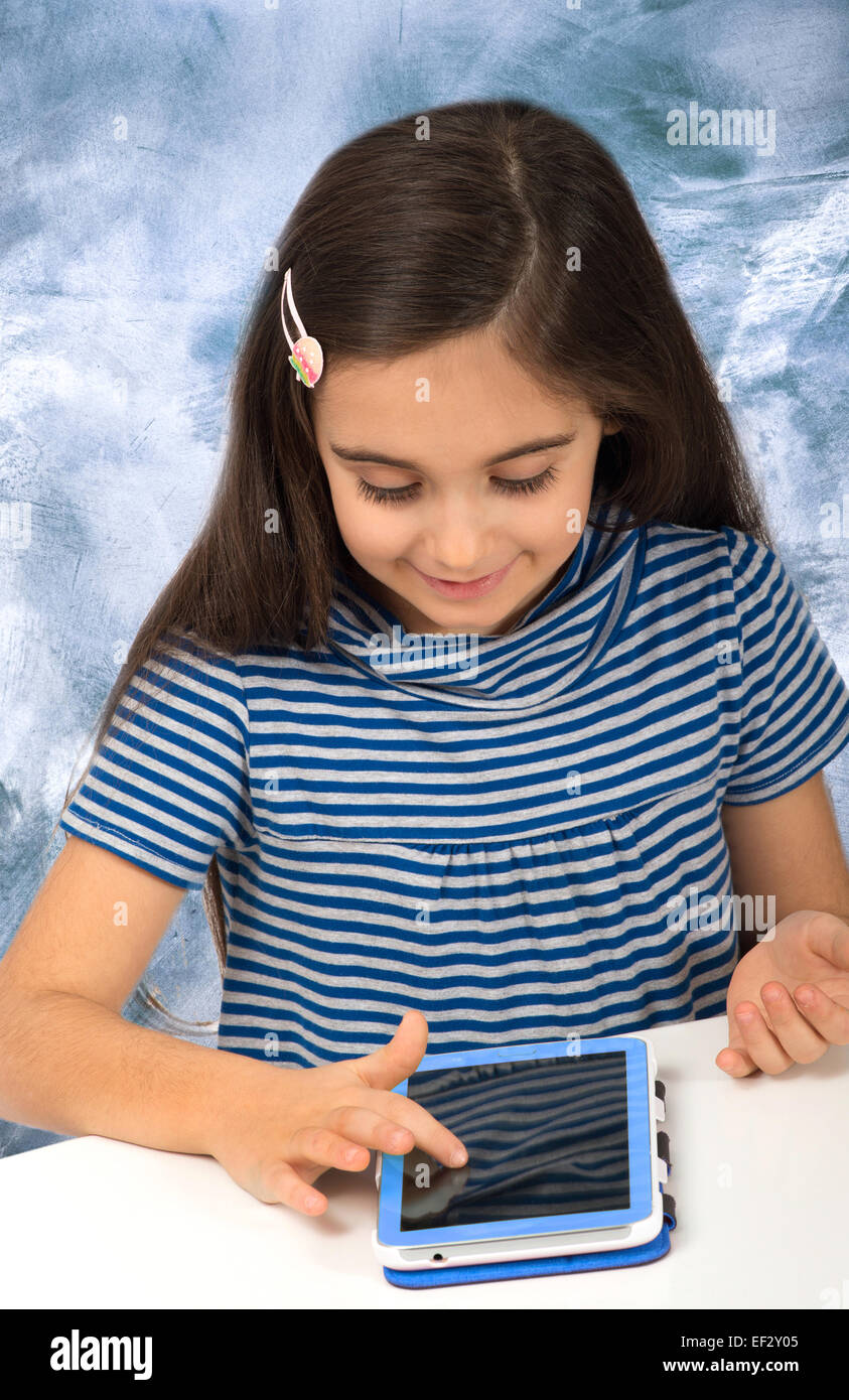 Smiling little girl playing on tablet Stock Photo - Alamy