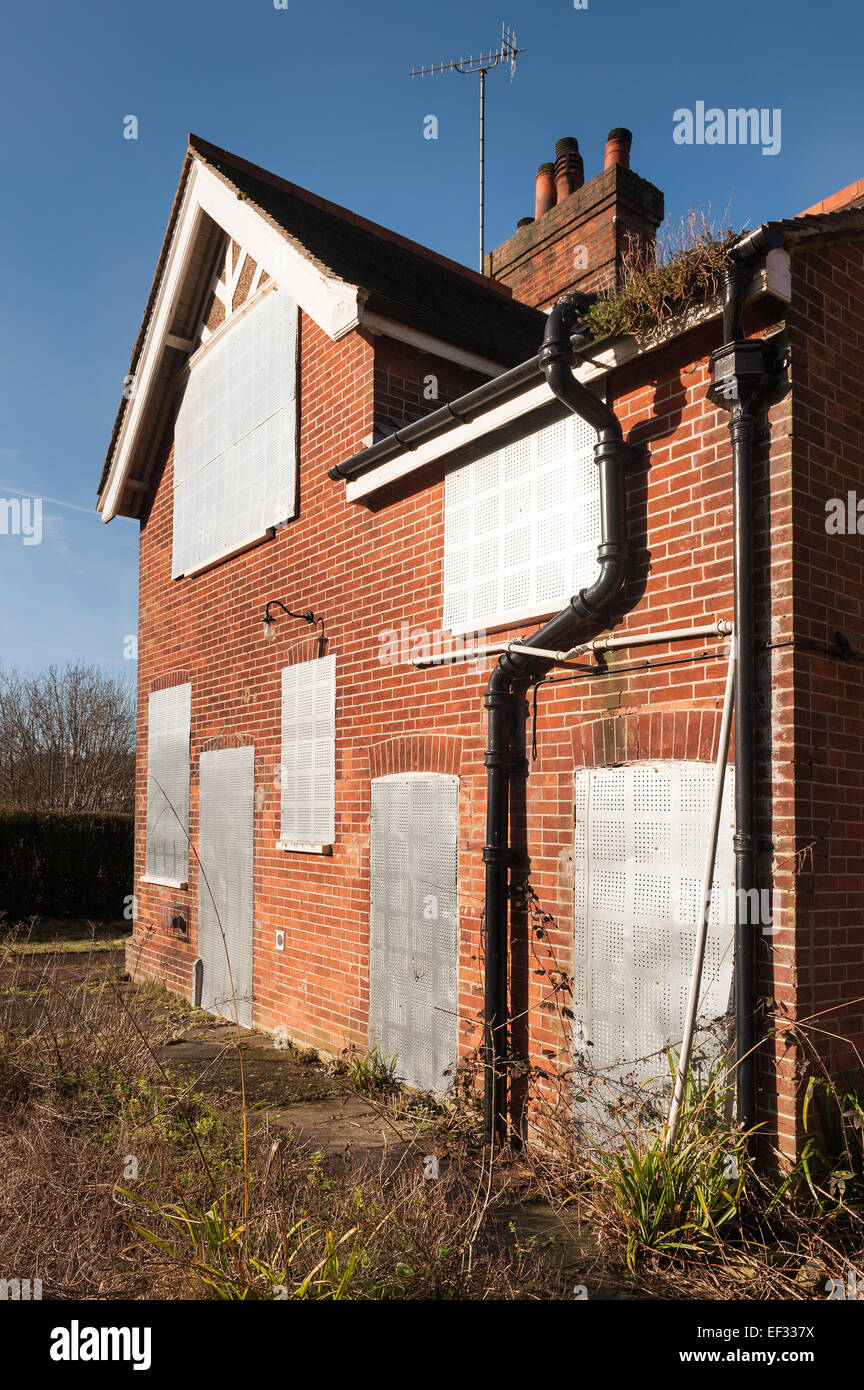 detached house in overgrown garden with metal security sheets boarded ...