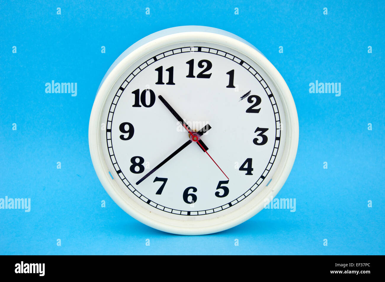 white clock dial clock-face with black arrows on blue background Stock ...