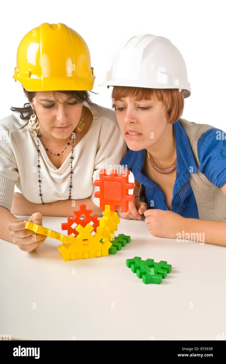 Two women playing with child's building toy Stock Photo - Alamy