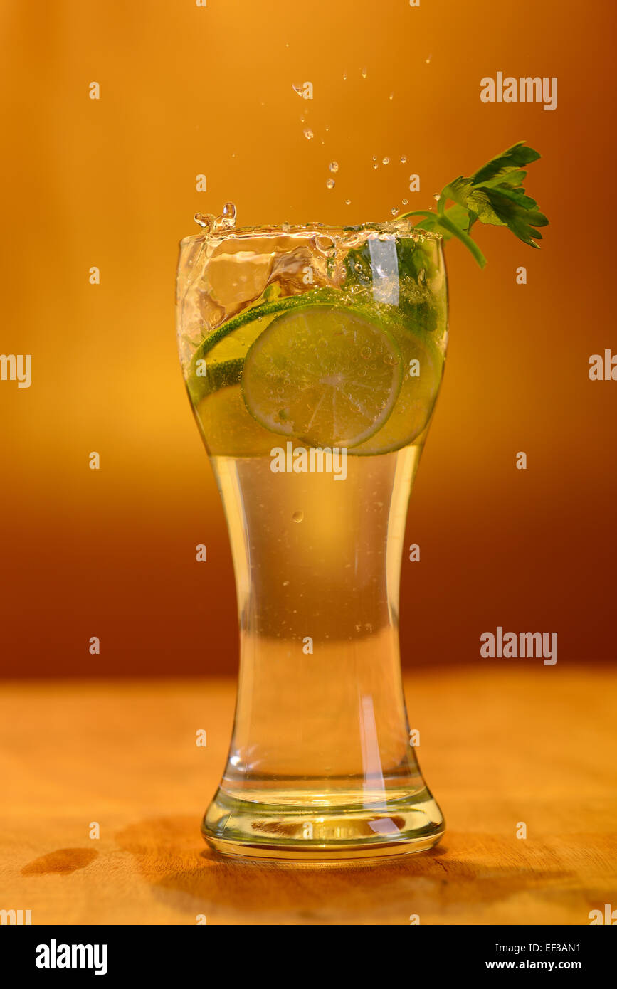 Full glass of fresh cool tonic with lime fruits isolated on background ...