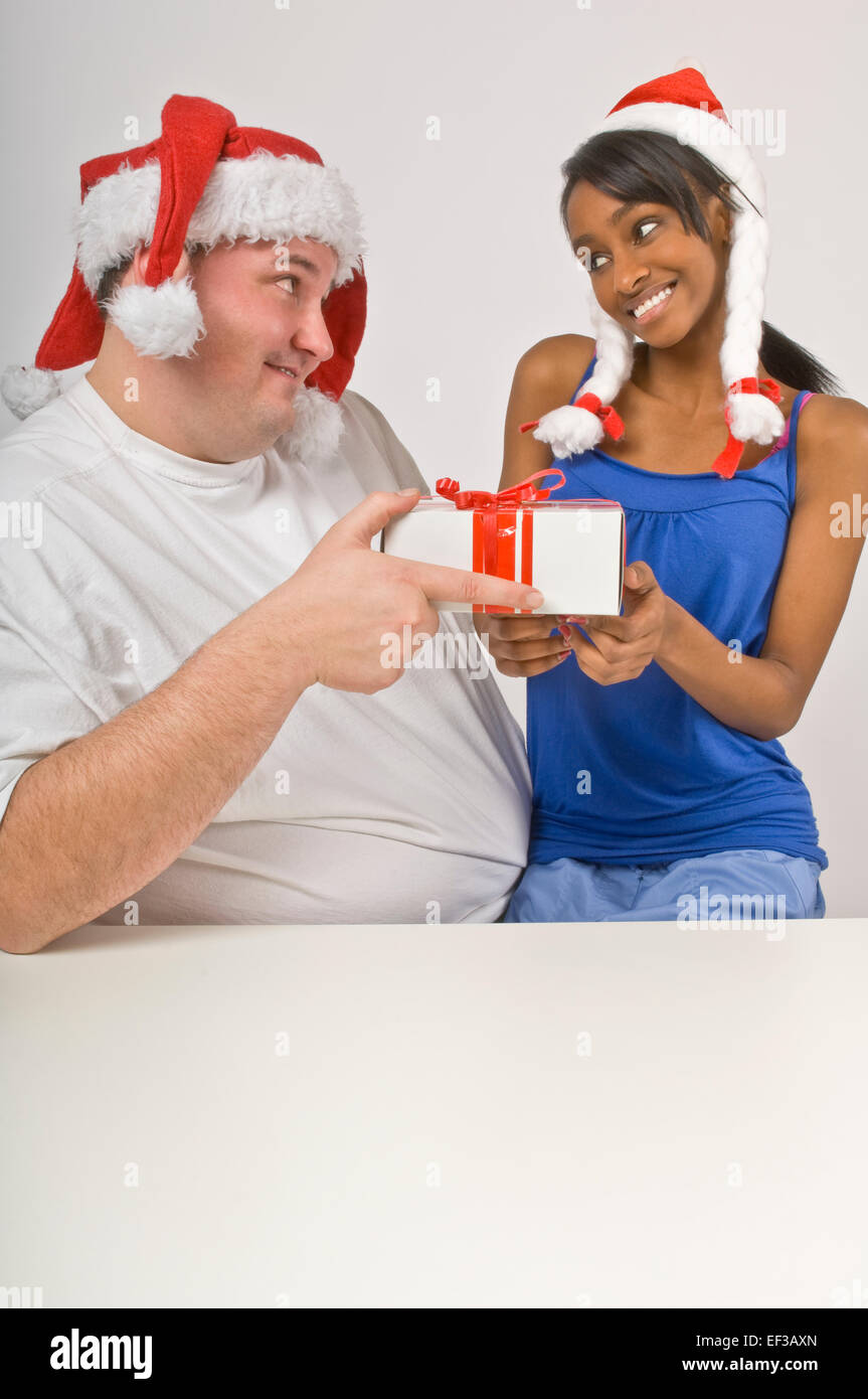 Overweight man giving Christmas present to slim woman Stock Photo - Alamy