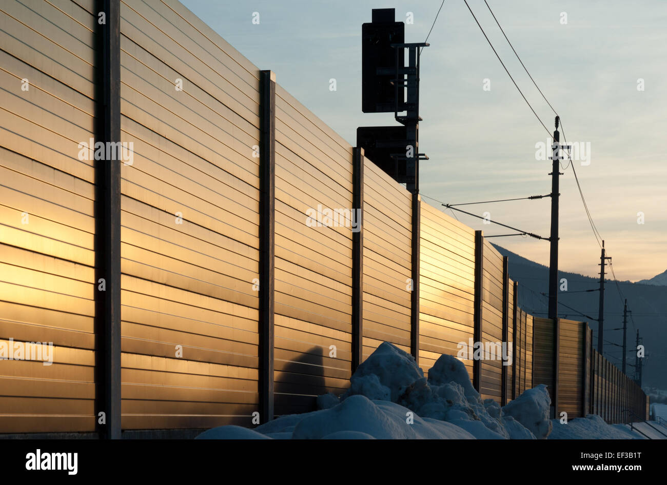 A noise barrier wall alongside a railway track, part of infrastructure ...
