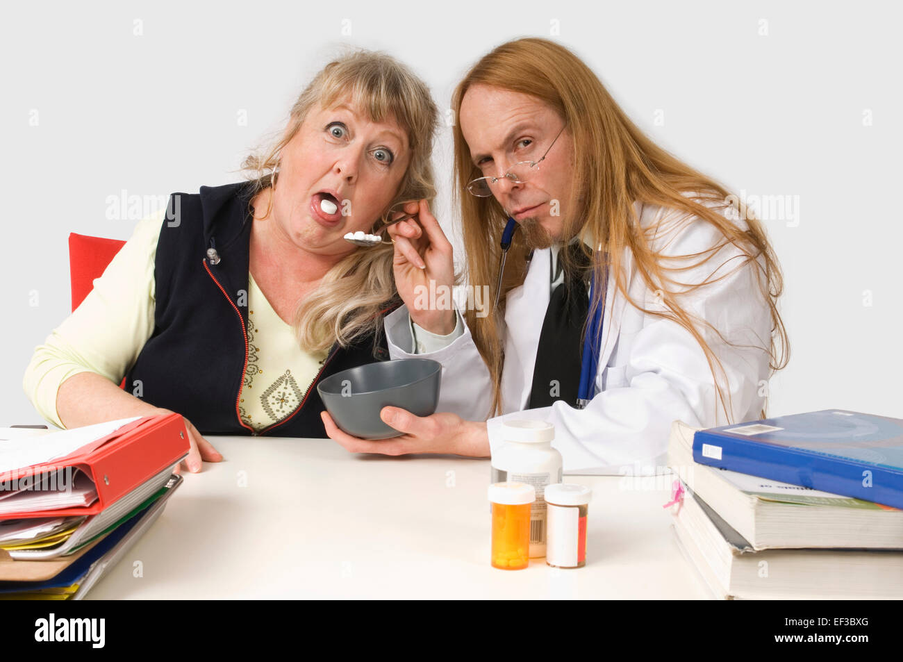Crazy looking doctor feeding pills to patient Stock Photo - Alamy