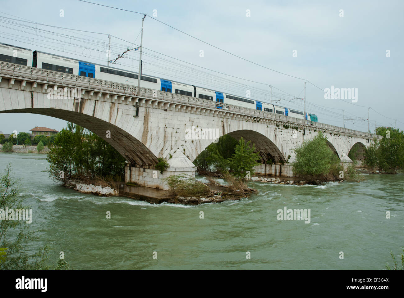 This photograph captures the Ponte Ferrovia (railway bridge) in Verona ...