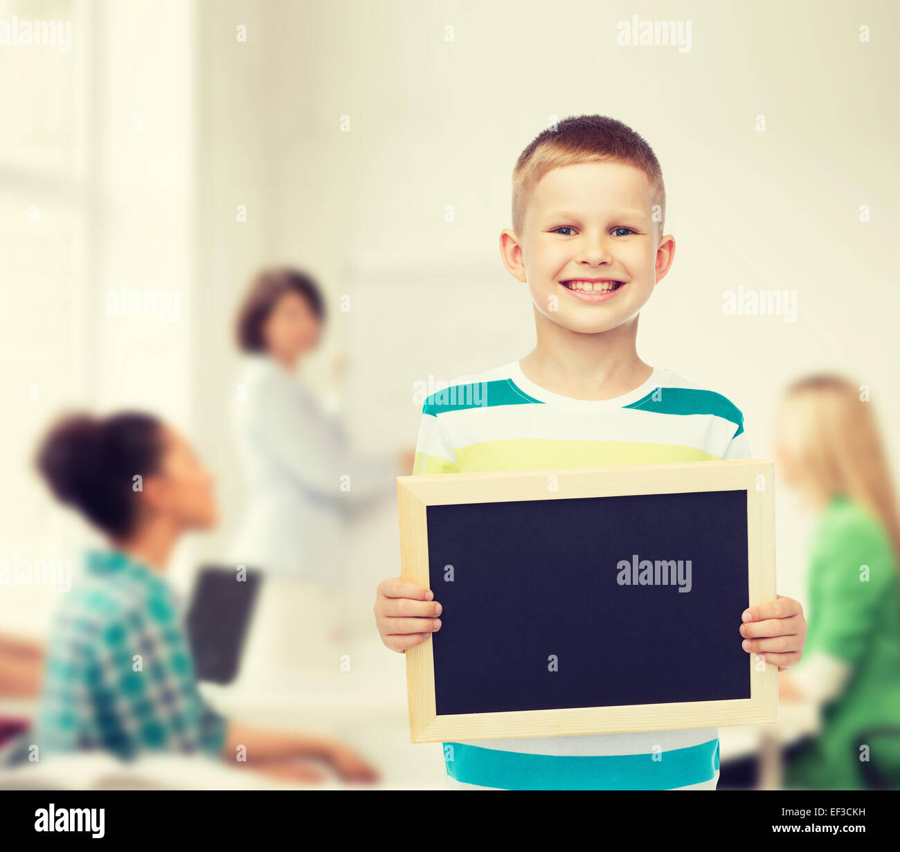 smiling little boy holding blank black chalkboard Stock Photo - Alamy