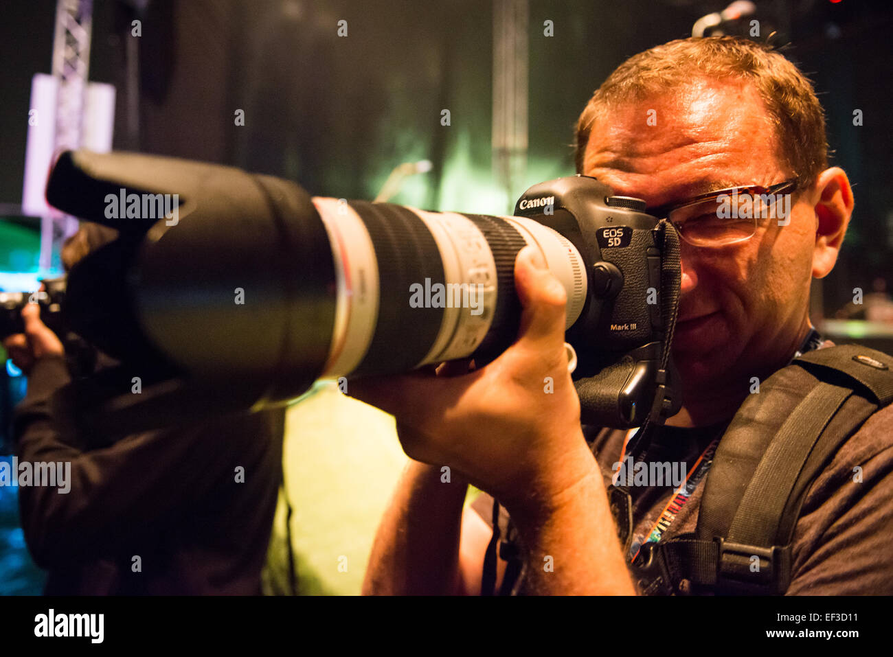 Professional photographer holds his camera shooting the audience from ...