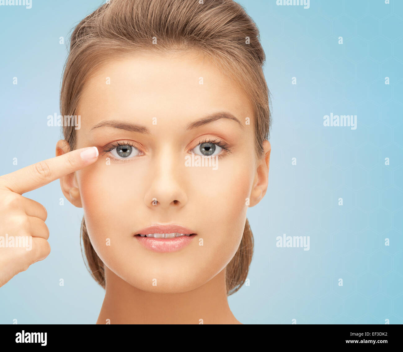 beautiful young woman pointing finger to her eye Stock Photo - Alamy