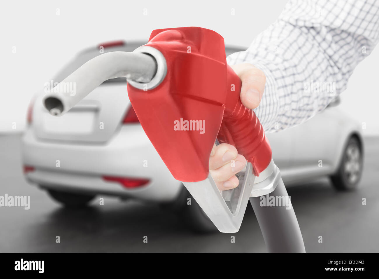 Red color fuel pump gun in hand with gray car on background Stock Photo ...