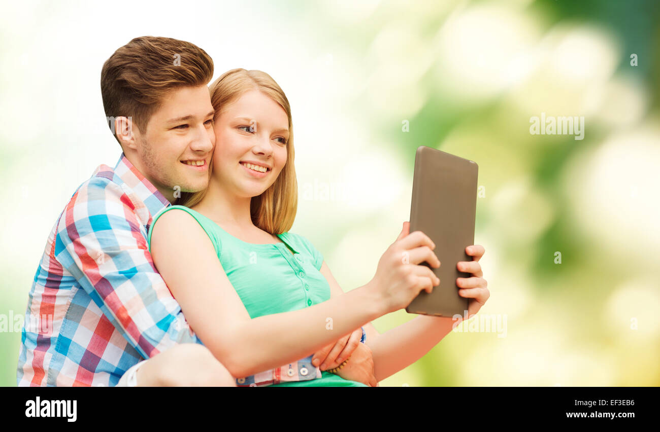 couple with tablet pc taking selfie over green Stock Photo - Alamy