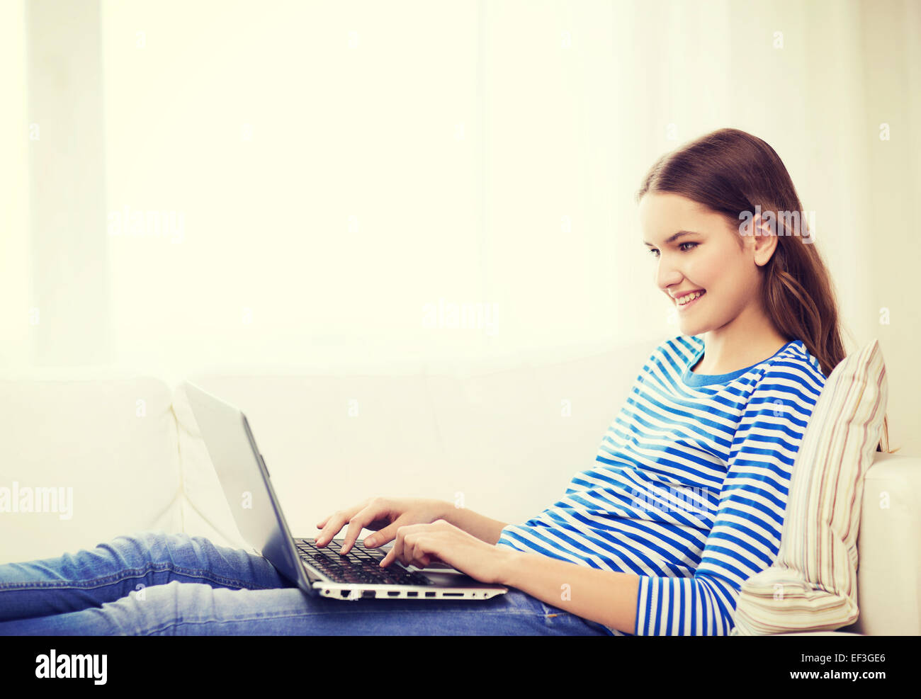 smiling teenage girl with laptop computer at home Stock Photo - Alamy