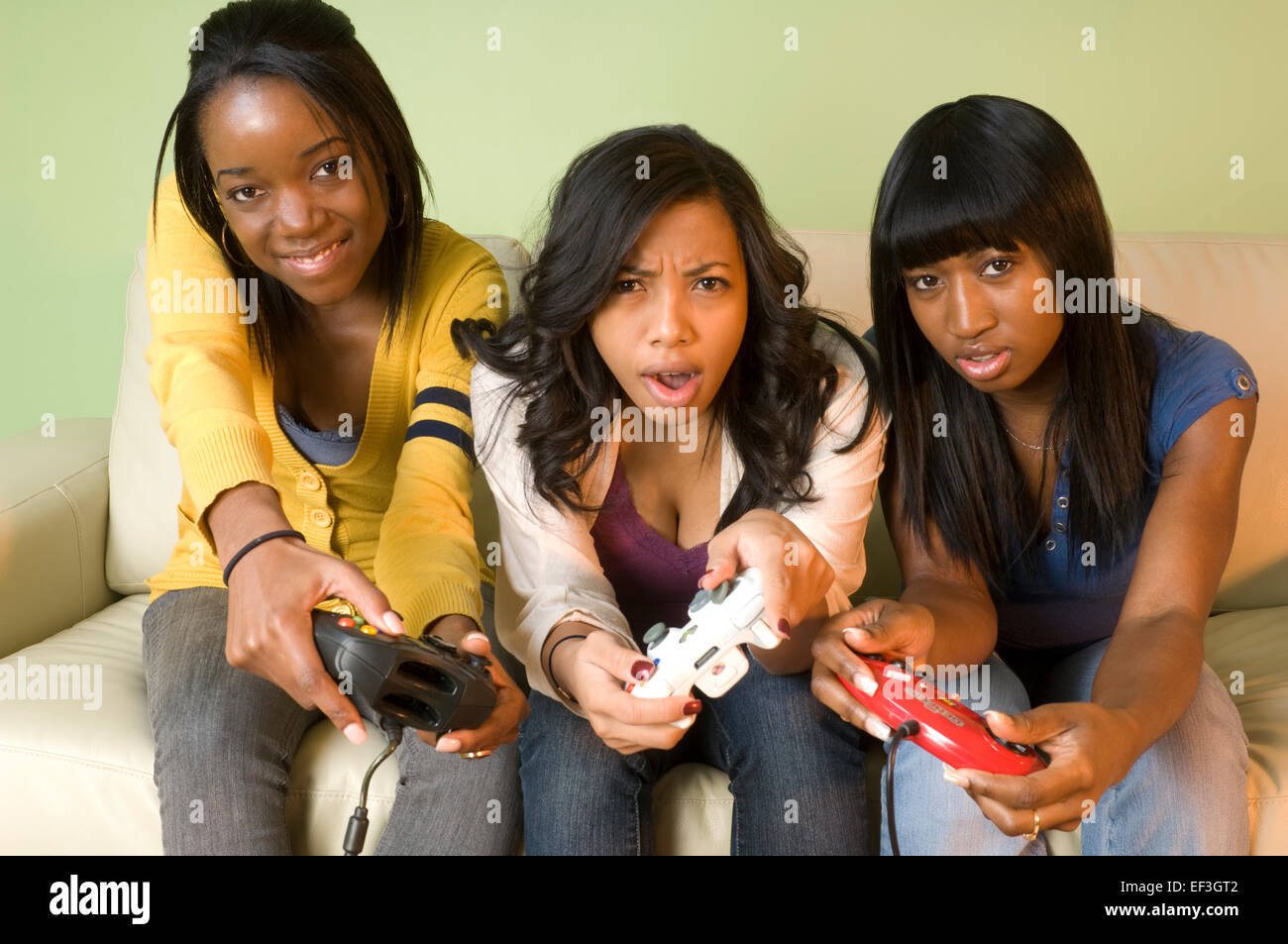 Three friends playing video game Stock Photo - Alamy