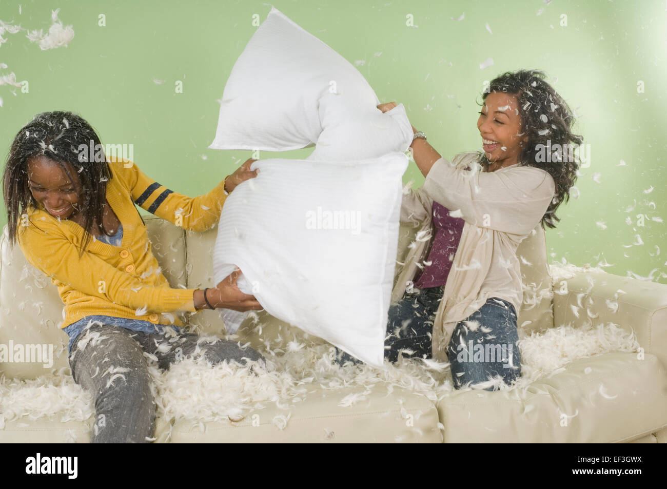 Two friends having pillow fight Stock Photo - Alamy