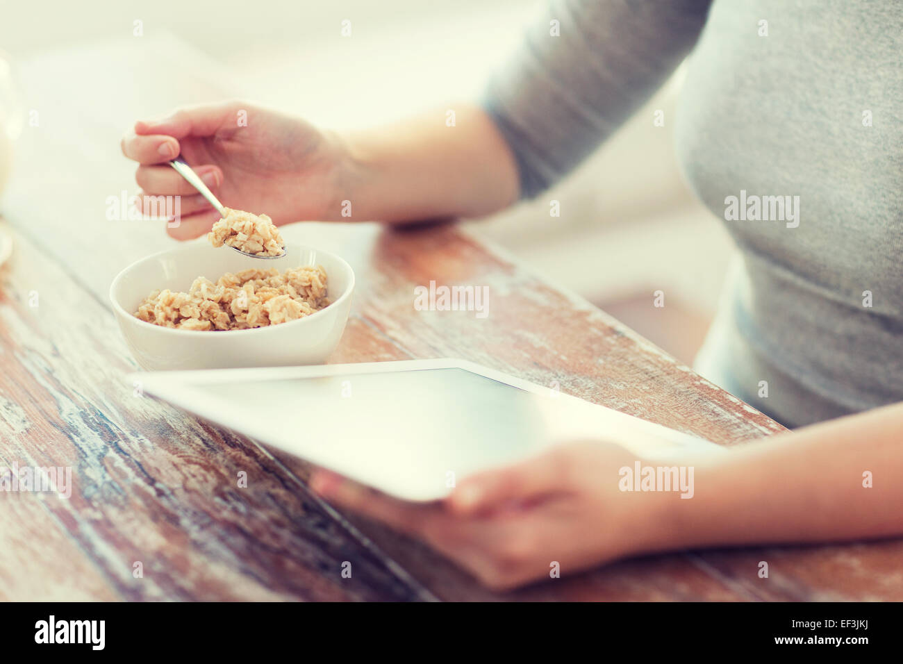 Woman having breakfast using tablet hi-res stock photography and images ...