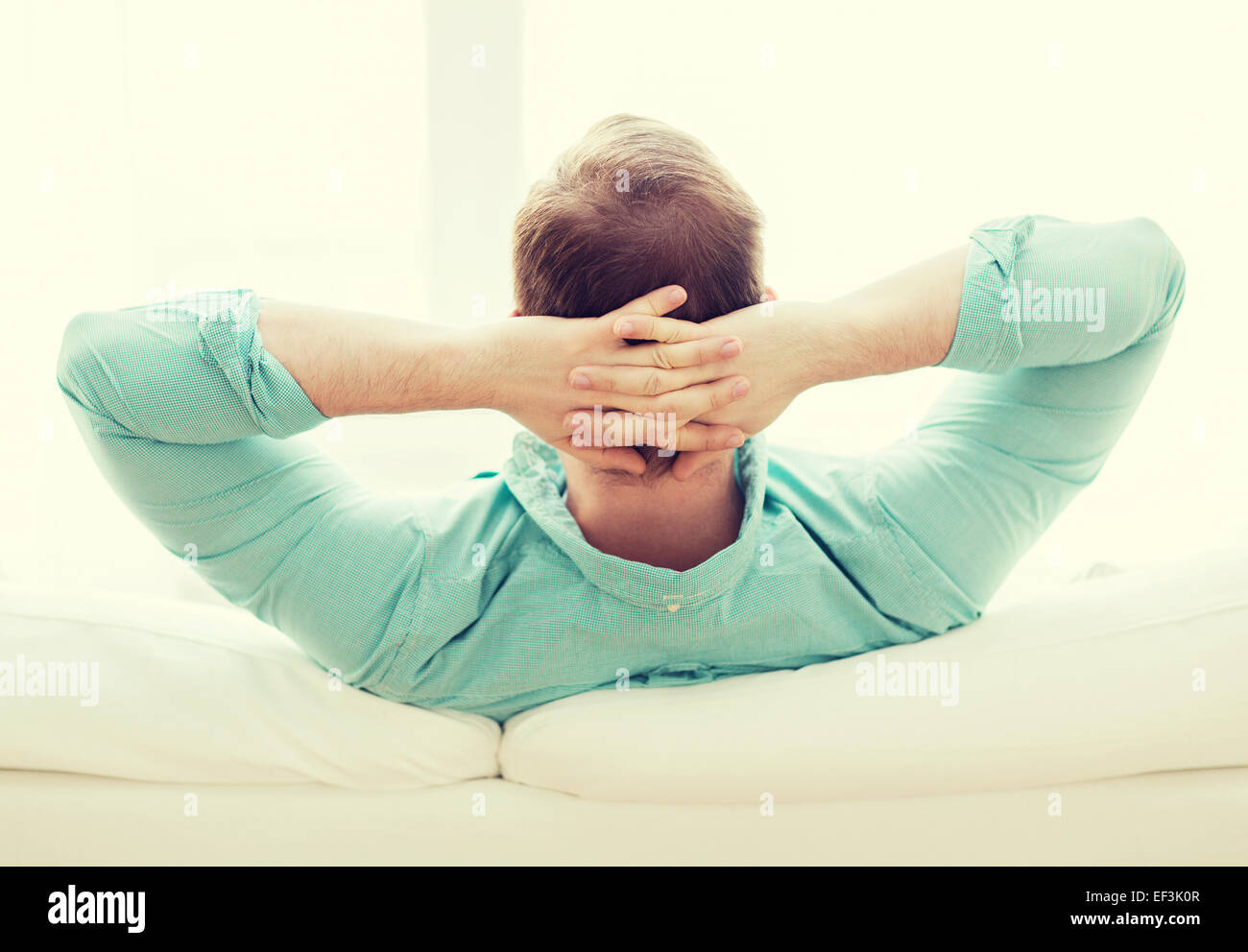 man lying or sitting on sofa at home from back Stock Photo - Alamy