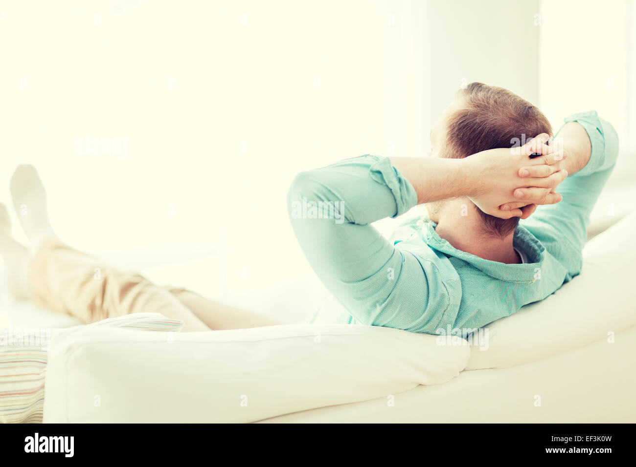 man lying or sitting on sofa at home from back Stock Photo - Alamy