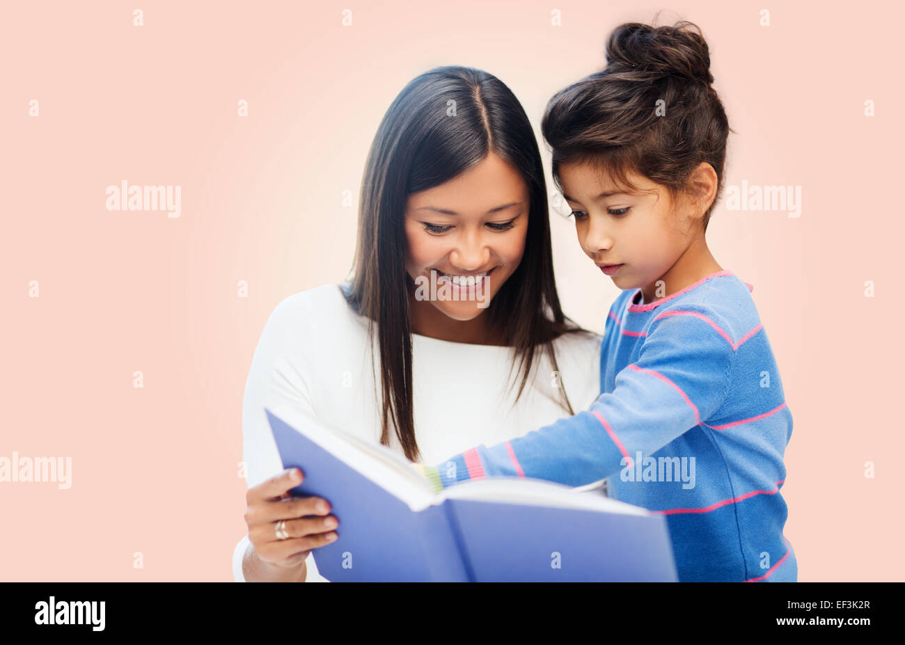happy mother and daughter reading book Stock Photo - Alamy