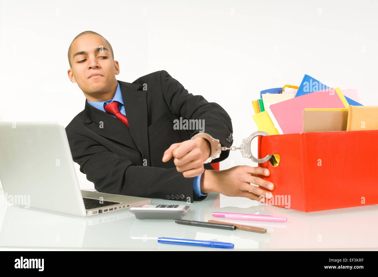 Businessman handcuffed to his work Stock Photo - Alamy