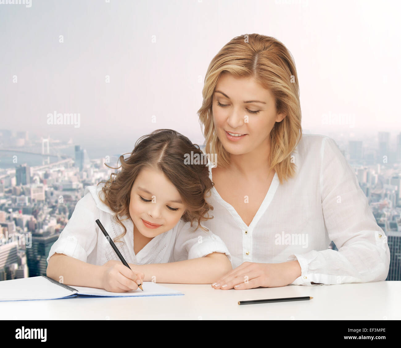happy mother and daughter writing in notebook Stock Photo - Alamy