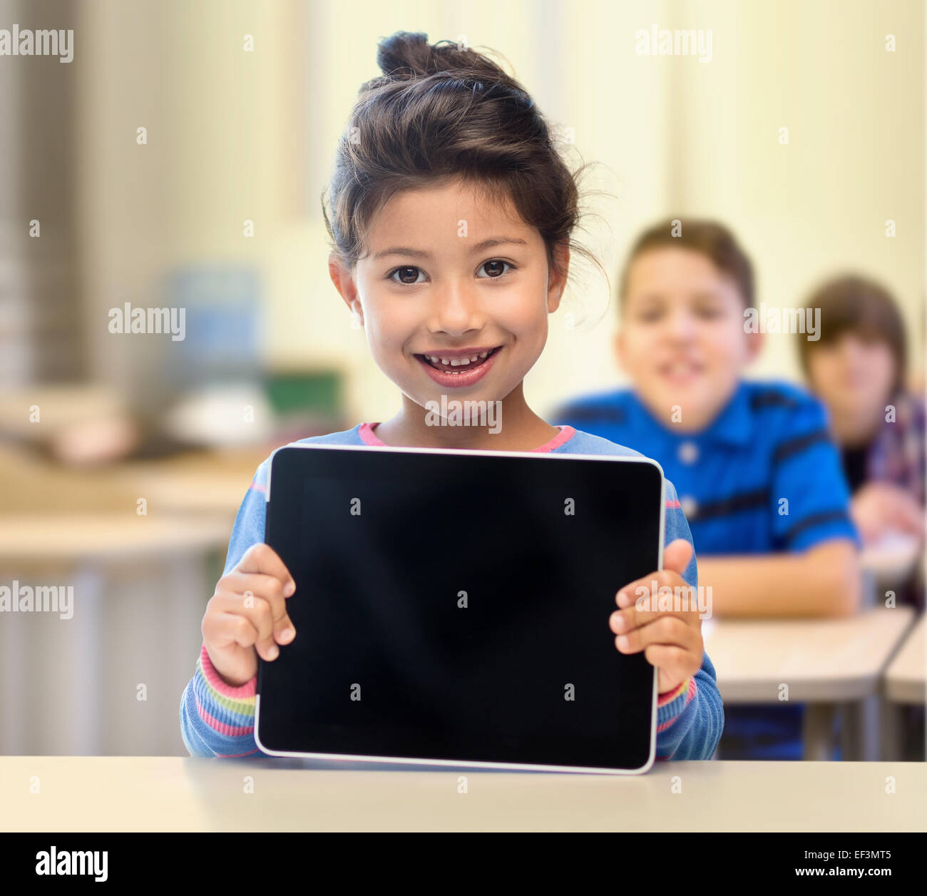 little school girl with tablet pc over classroom Stock Photo - Alamy