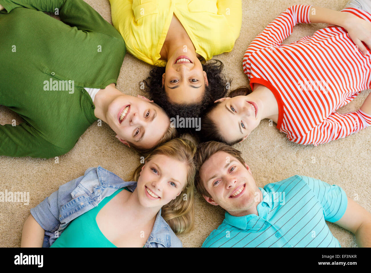group of smiling people lying down on floor Stock Photo - Alamy