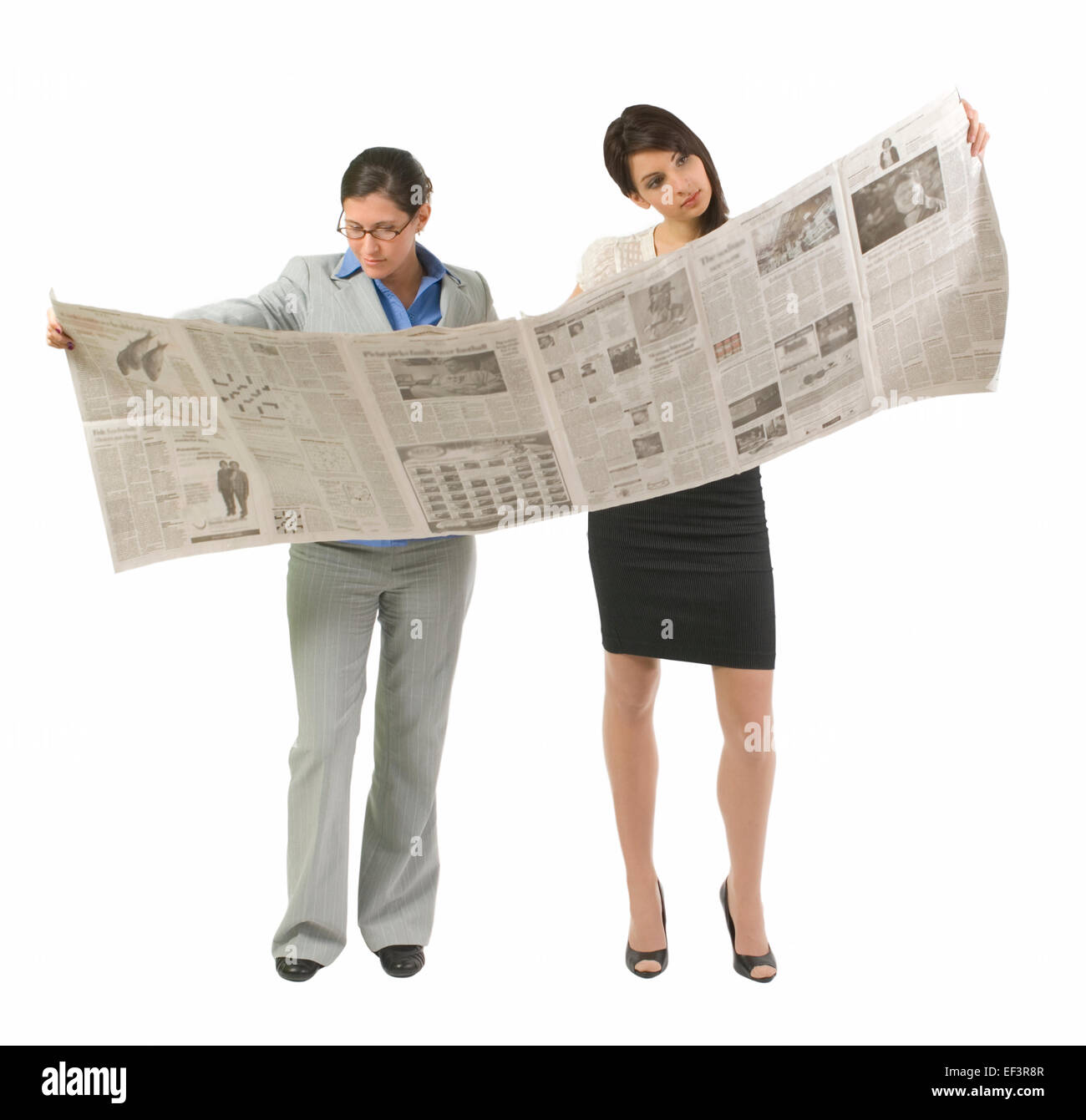 Two woman reading a very large newspaper Stock Photo - Alamy