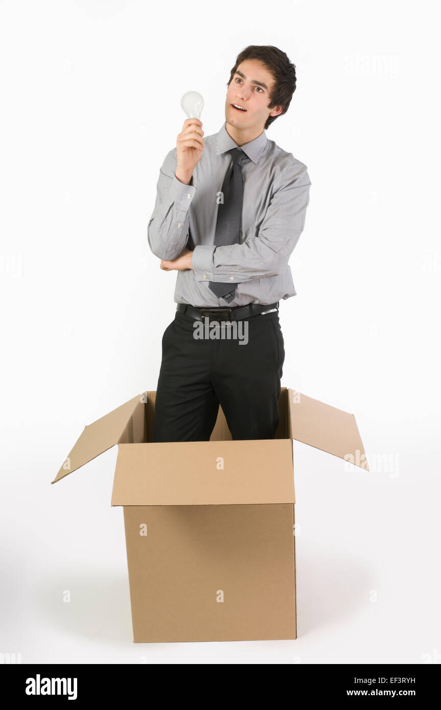 Man standing in a box and holding a light bulb Stock Photo - Alamy