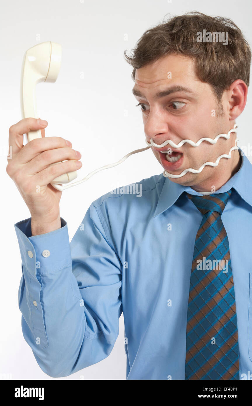 Frustrated man wrapped in phone cord Stock Photo - Alamy