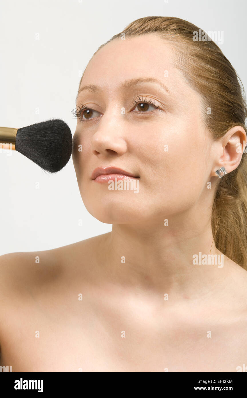 Woman putting make-up on Stock Photo - Alamy