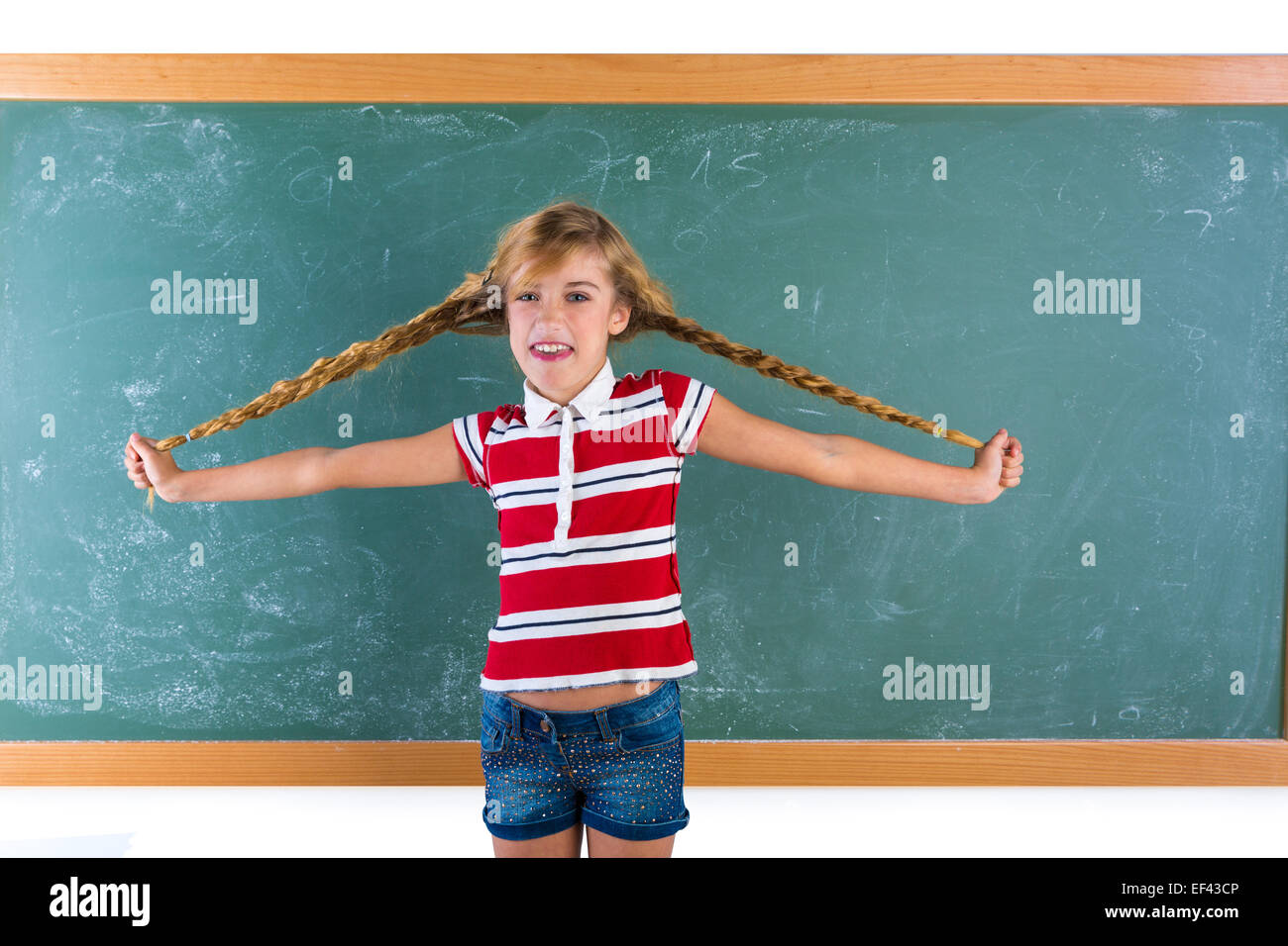 Braided student blond girl playing in green chalkboard with braids at ...