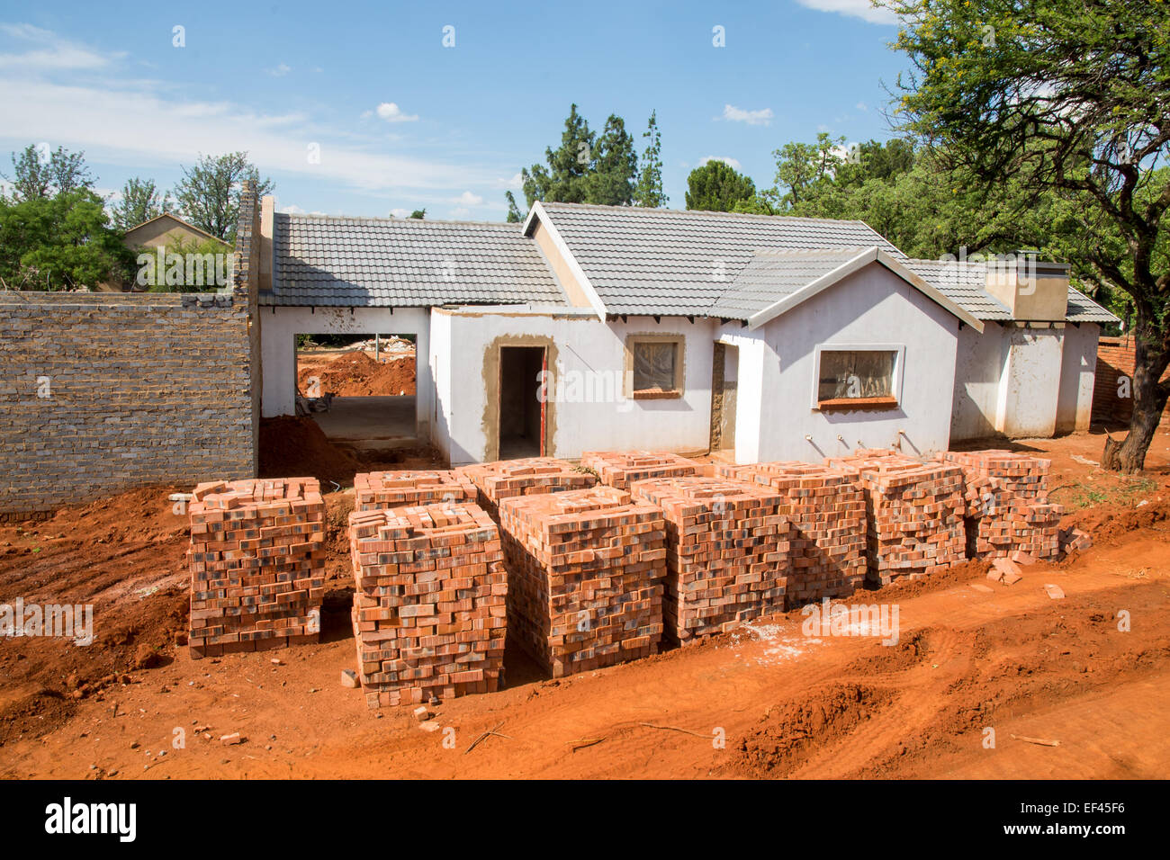 Stacked bricks in front of an incomplete house Stock Photo - Alamy
