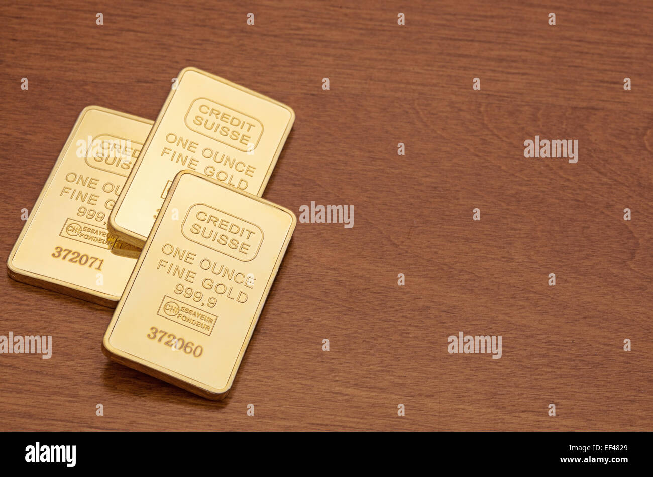 One ounce gold bars on dark wood surface Stock Photo - Alamy