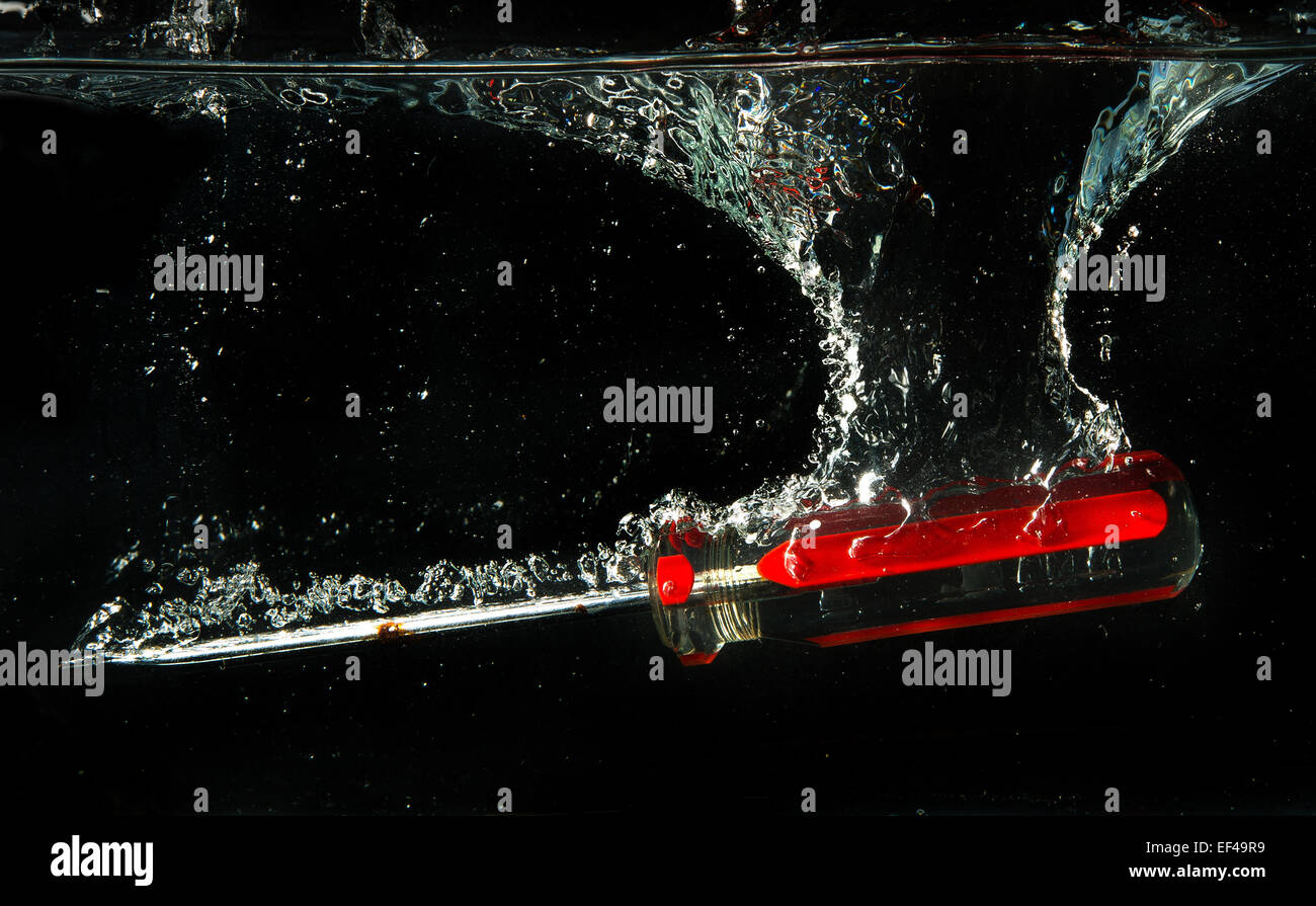 A screwdriver splashes into water Stock Photo - Alamy