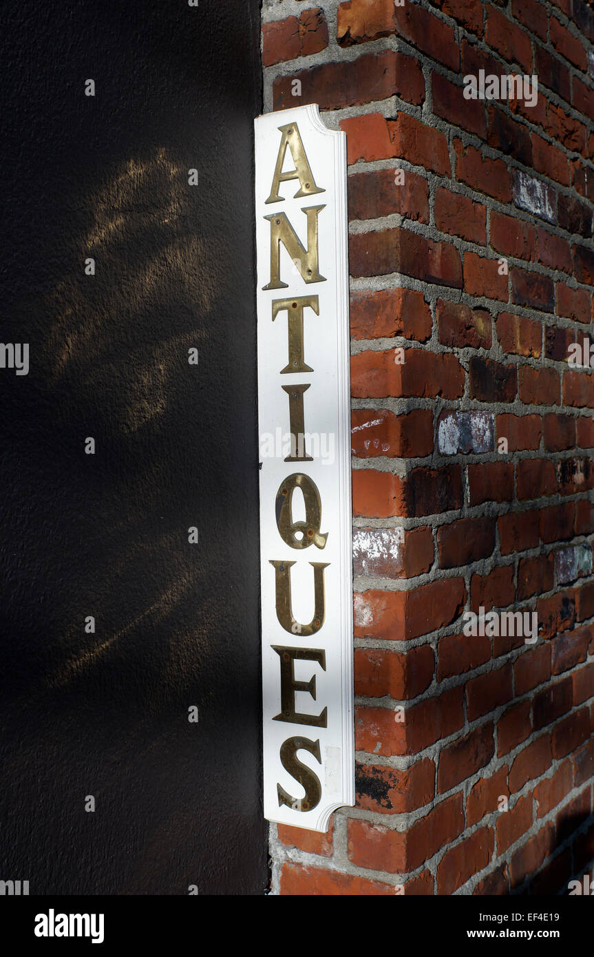 Antiques store sign on a brick wall Stock Photo - Alamy