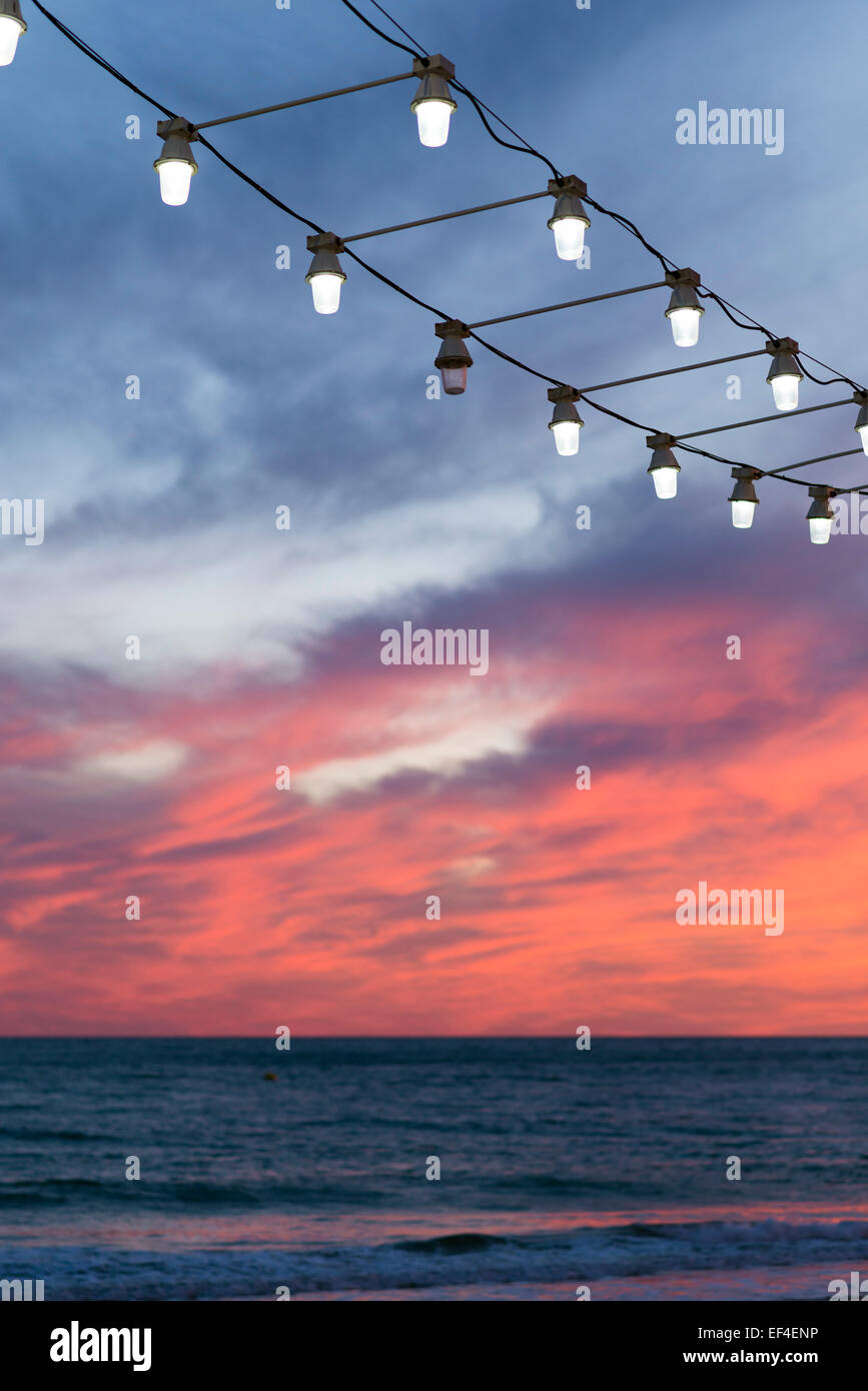 row of light bulbs on the beach at sunset Stock Photo - Alamy