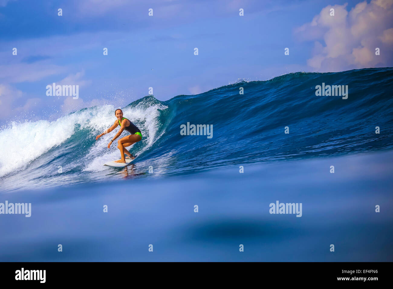 Surfer girl on Amazing Blue Wave, Bali island Stock Photo - Alamy
