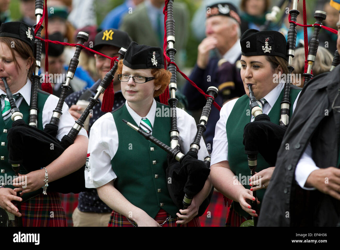 A girl with red hair holding a set of bagpipes before the start of ...