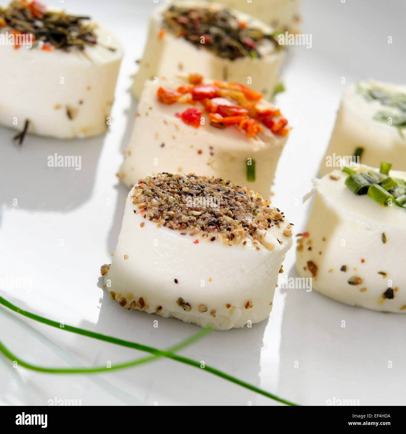 a plate with some different cheese canapes topped with different spices ...