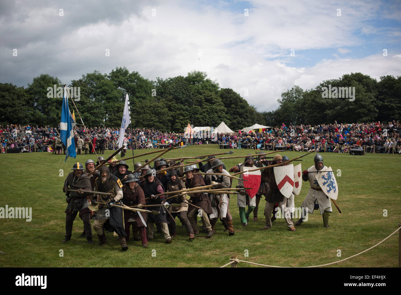 Participants dressed as Scottish soldiers taking part in a battle scene ...