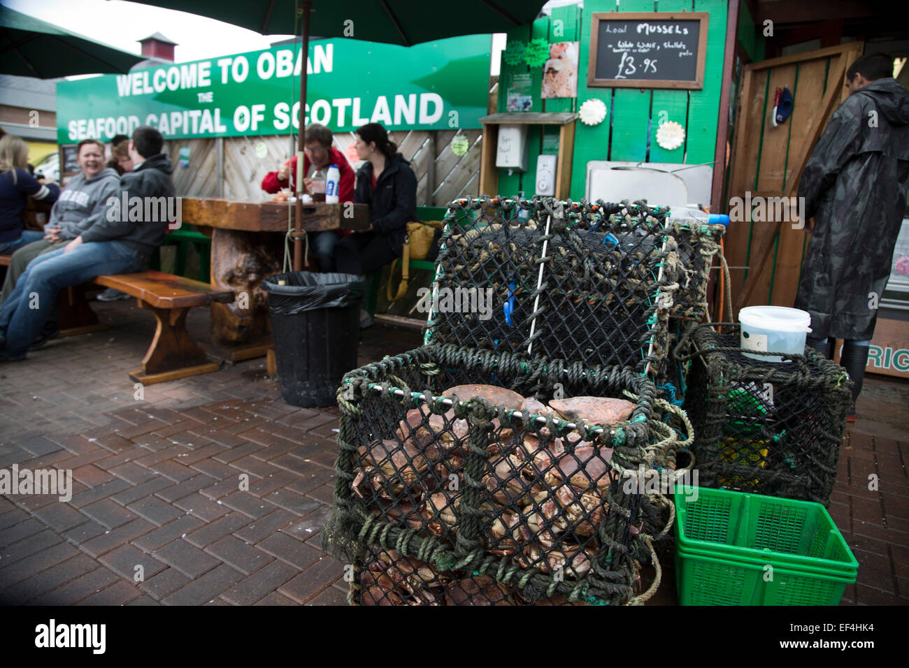 People eating seafood at an outside cafe on the pier in Oban, Argyll ...