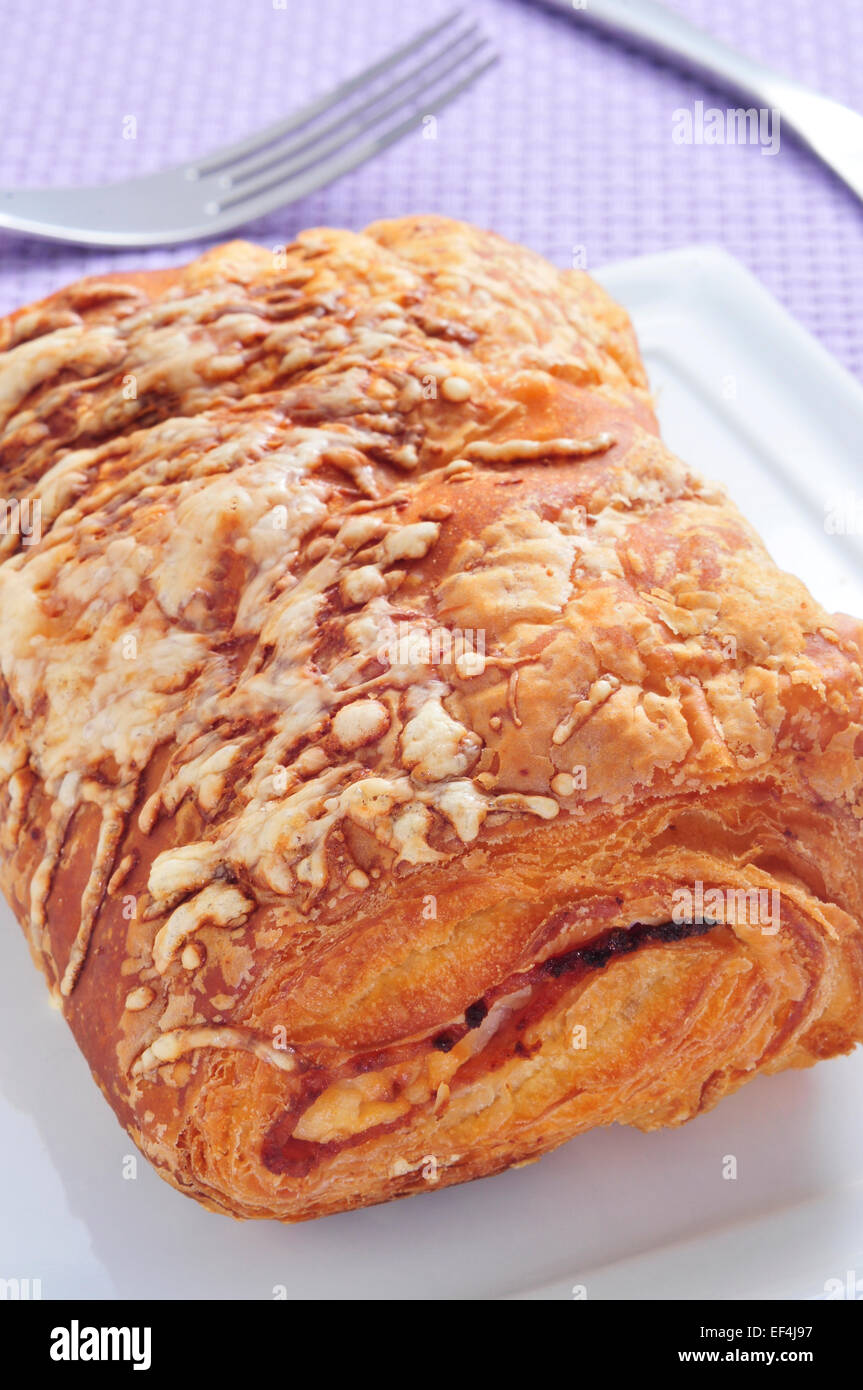 plate with a ham and cheese croissant on a set table with a purple ...