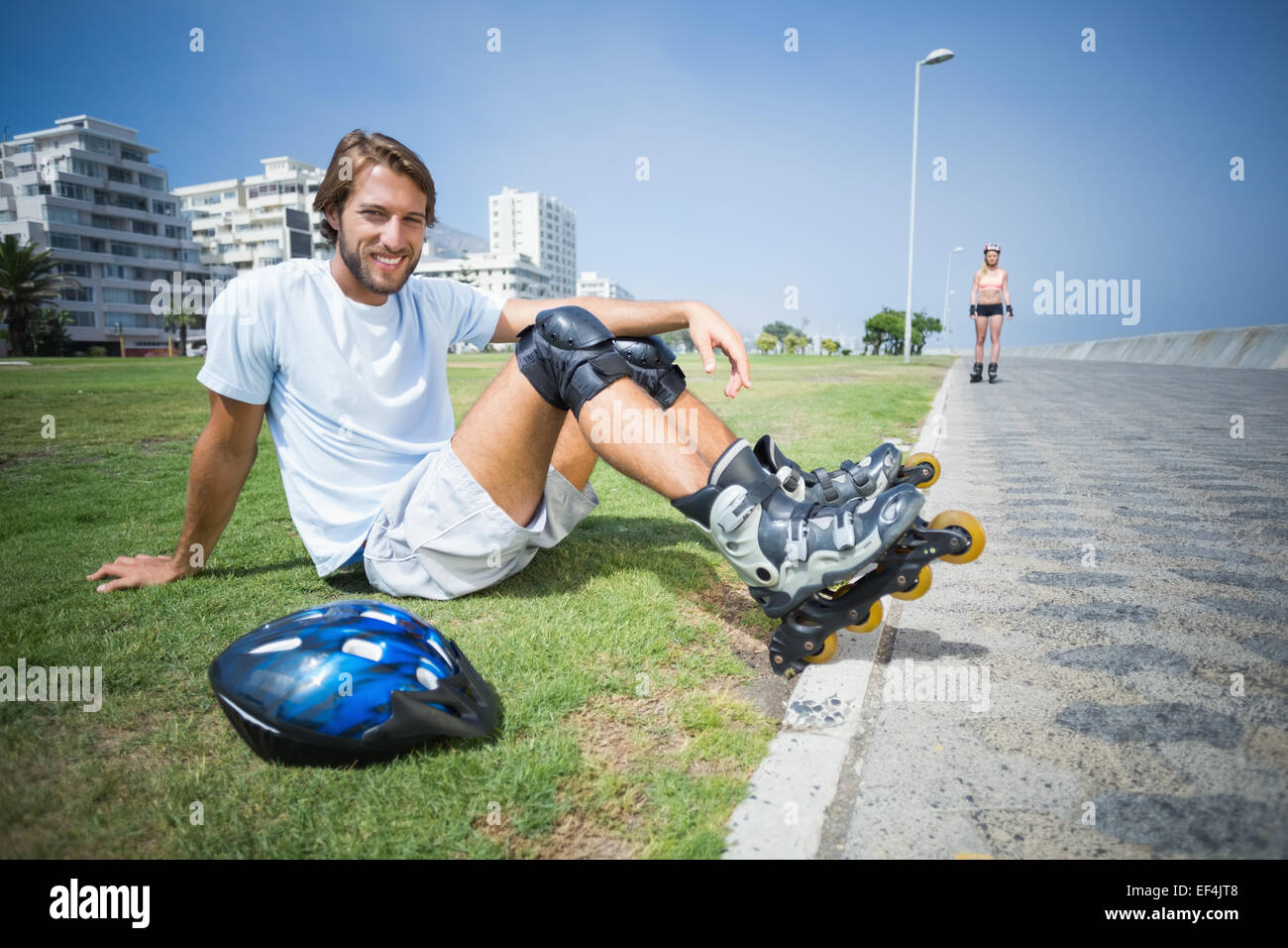Fit man getting ready to roller blade Stock Photo - Alamy